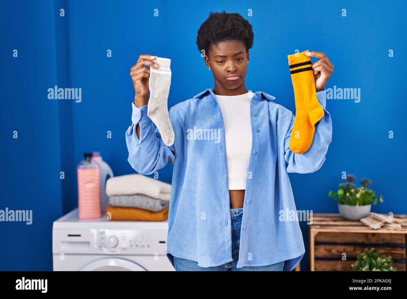 African american woman holding clean andy dirty socks depressed and ...