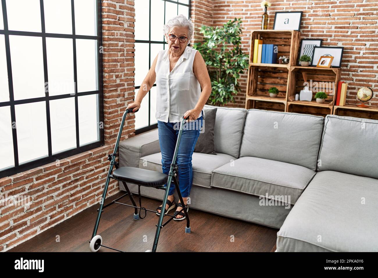 Senior grey-haired woman patient supported for walker at geriatric ...