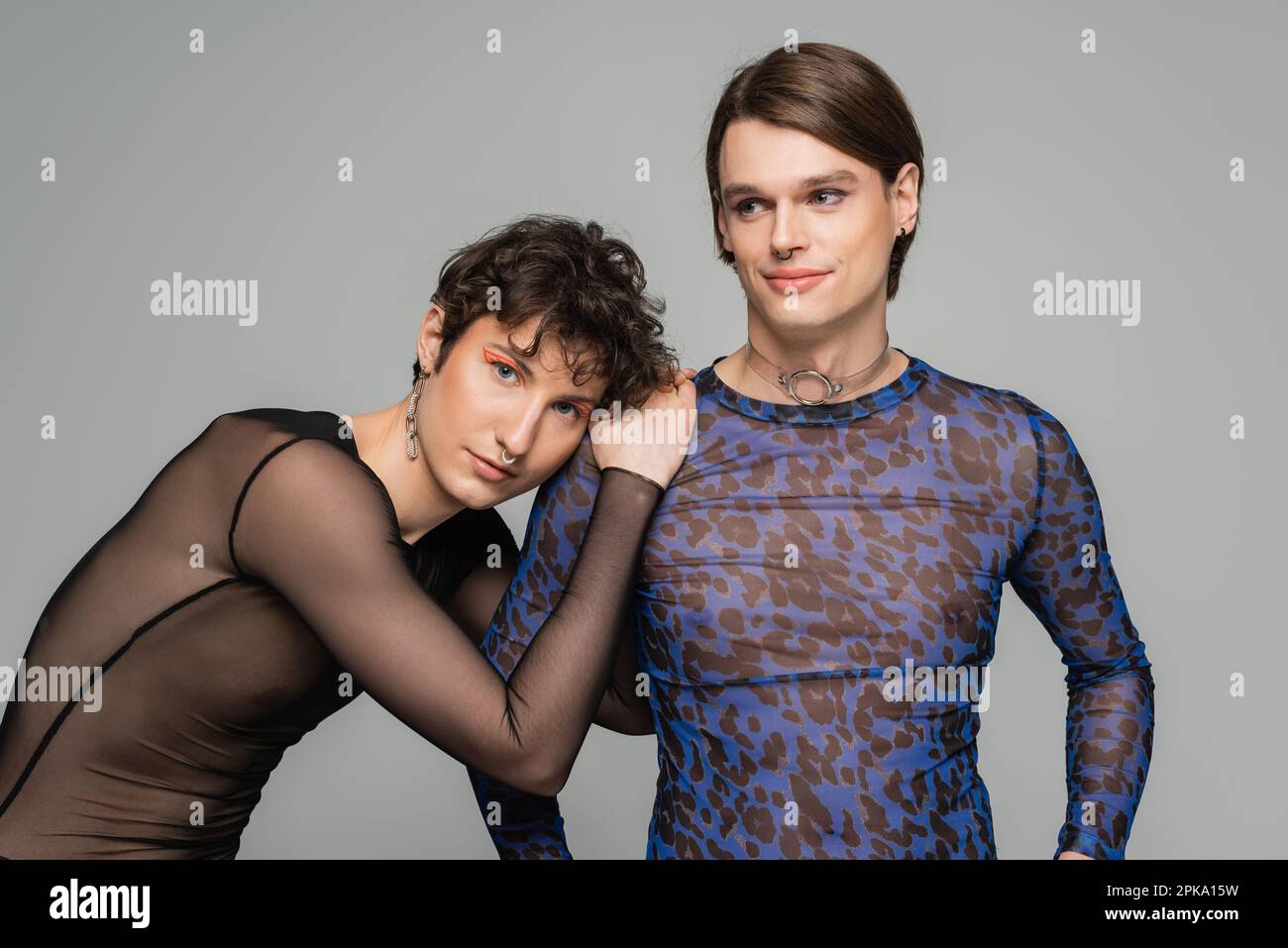 bigender person in black transparent top leaning on stylish partner ...