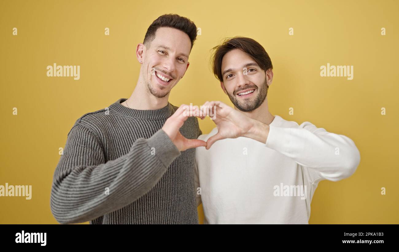 Two men couple hugging each other doing heart gesture over isolated ...