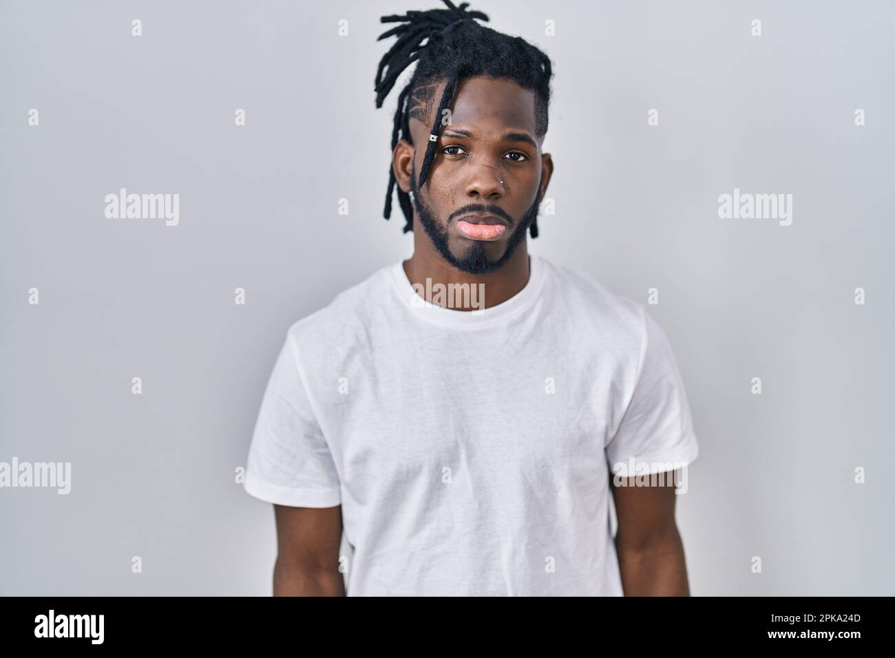 African man with dreadlocks wearing casual t shirt over white ...