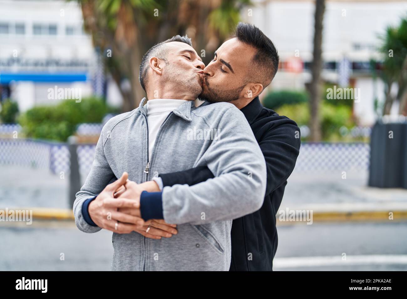 Two men couple hugging each other kissing at street Stock Photo - Alamy