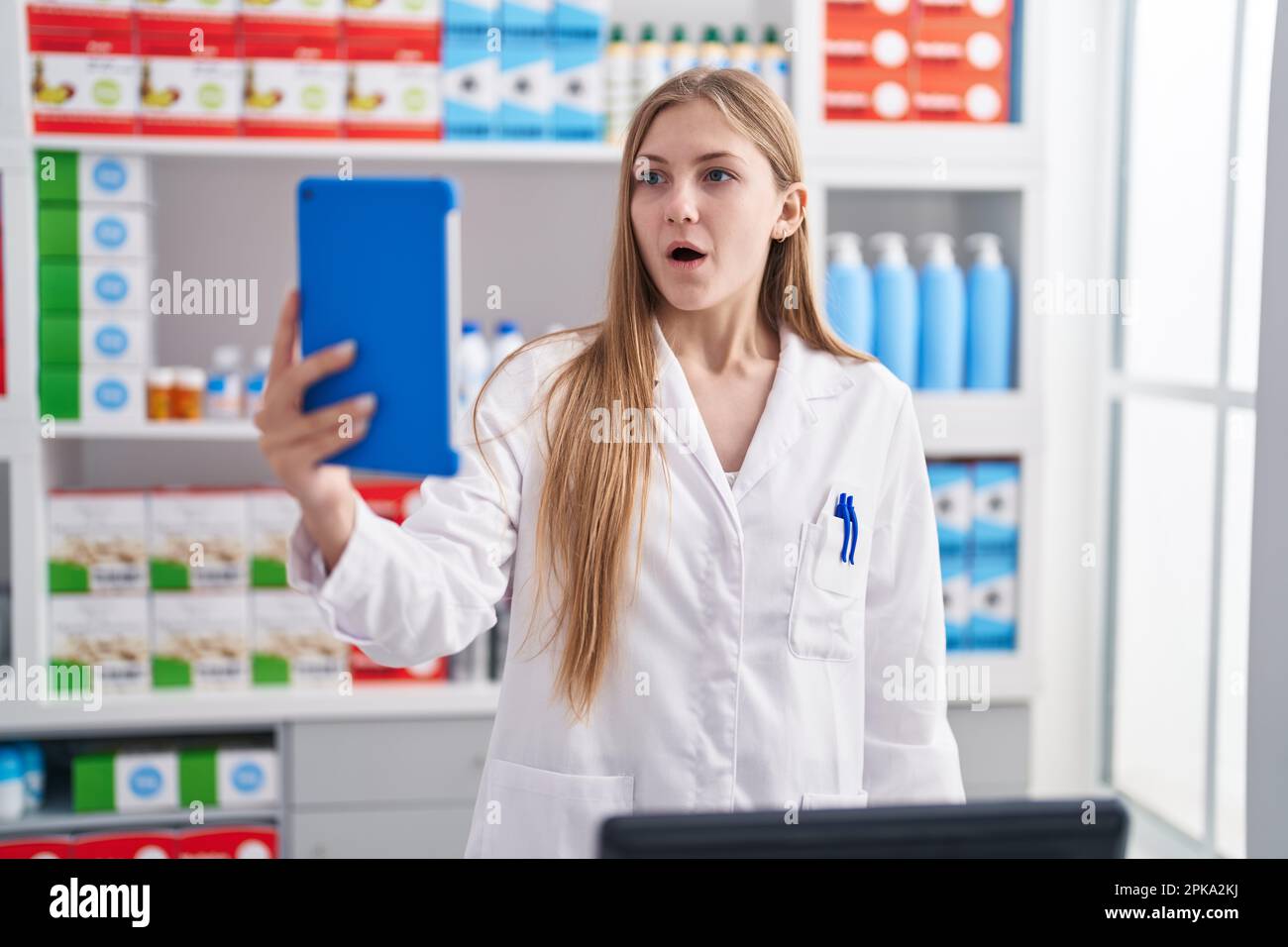 Young caucasian woman working at pharmacy drugstore doing video call ...