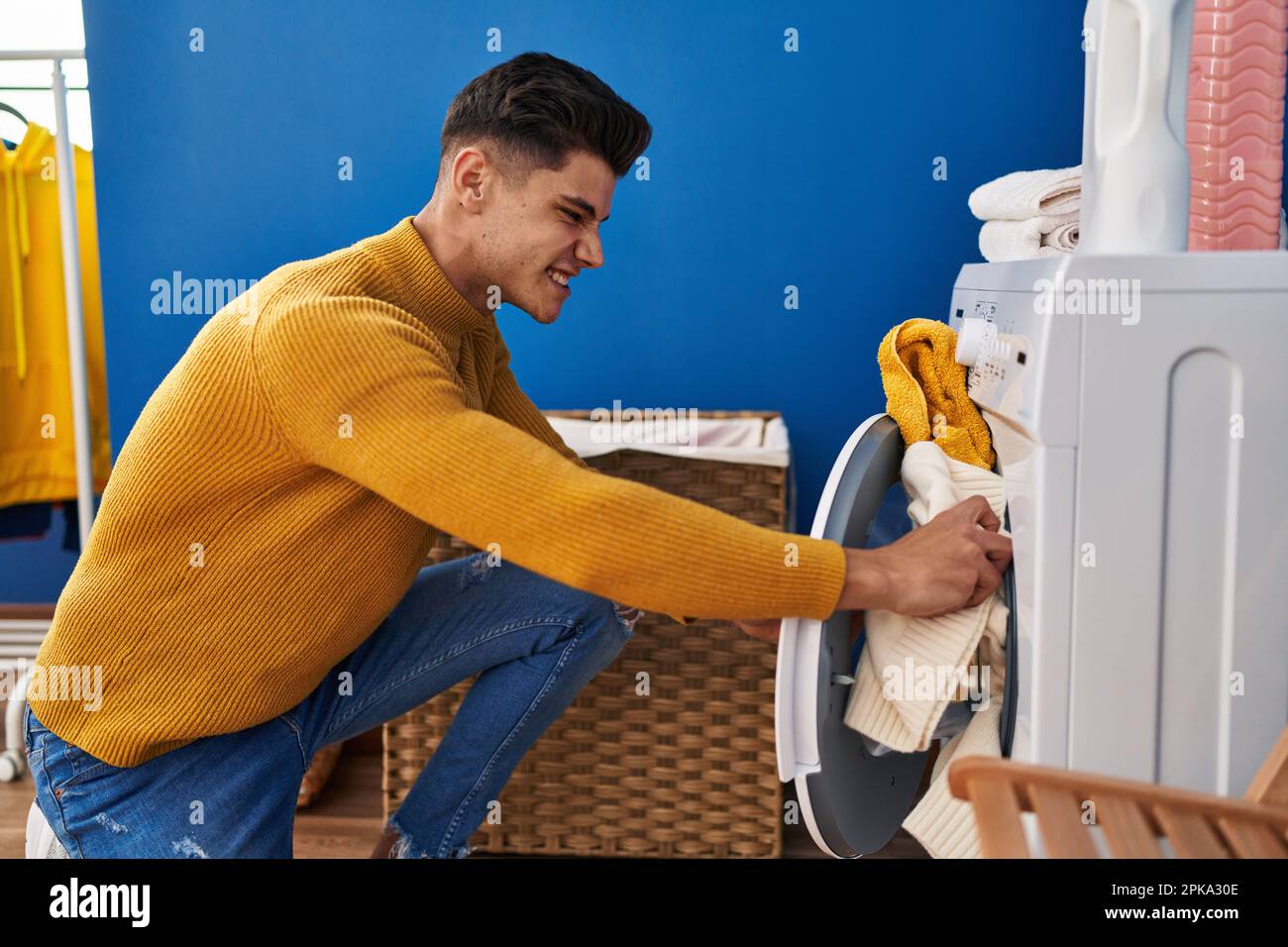 Young hispanic man washing clothes at laundry Stock Photo - Alamy