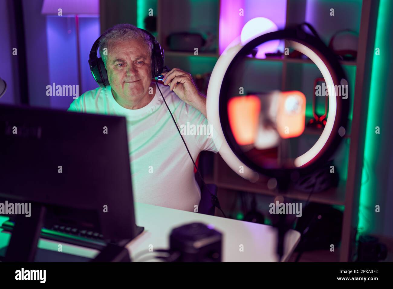 Middle age grey-haired man streamer smiling confident having video call ...