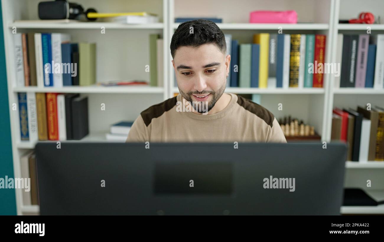 Young arab man student using computer studying at university classroom ...