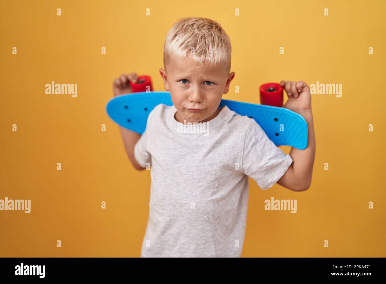 Little caucasian boy holding skate depressed and worry for distress ...