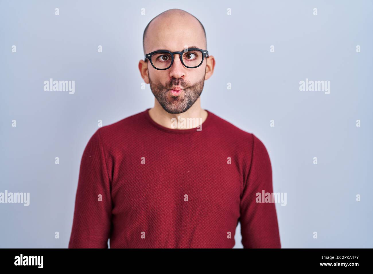 Young bald man with beard standing over white background wearing ...