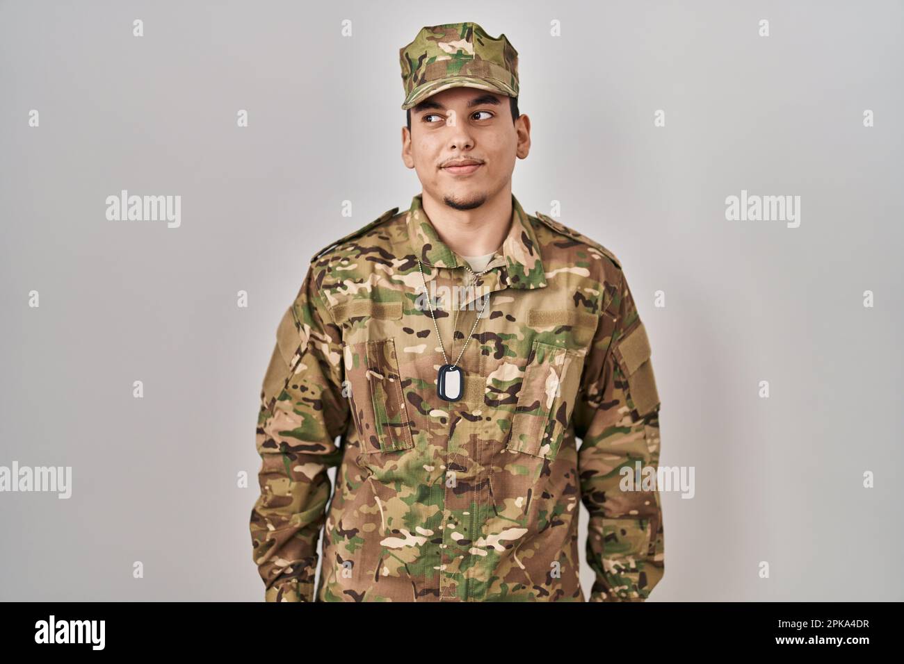 Young arab man wearing camouflage army uniform smiling looking to the ...