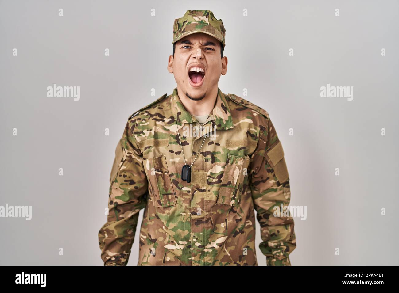 Young arab man wearing camouflage army uniform angry and mad screaming ...