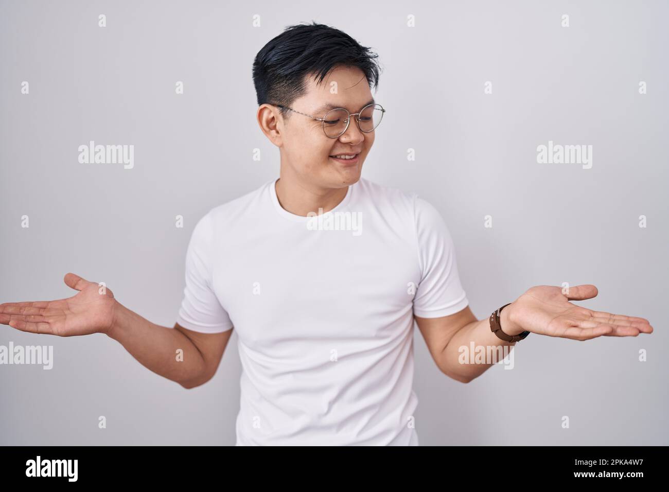 Young asian man standing over white background smiling showing both ...