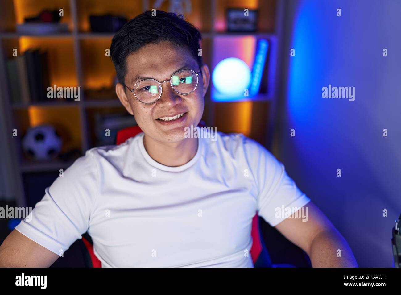 Young chinese man streamer smiling confident sitting on table at gaming ...