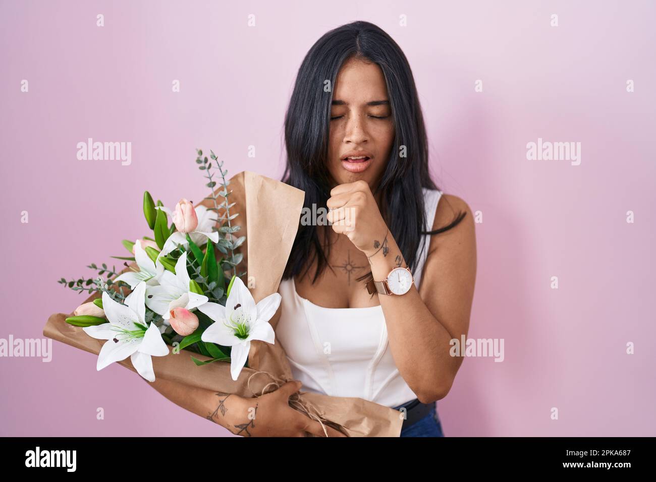 Brunette woman holding bouquet of white flowers feeling unwell and ...