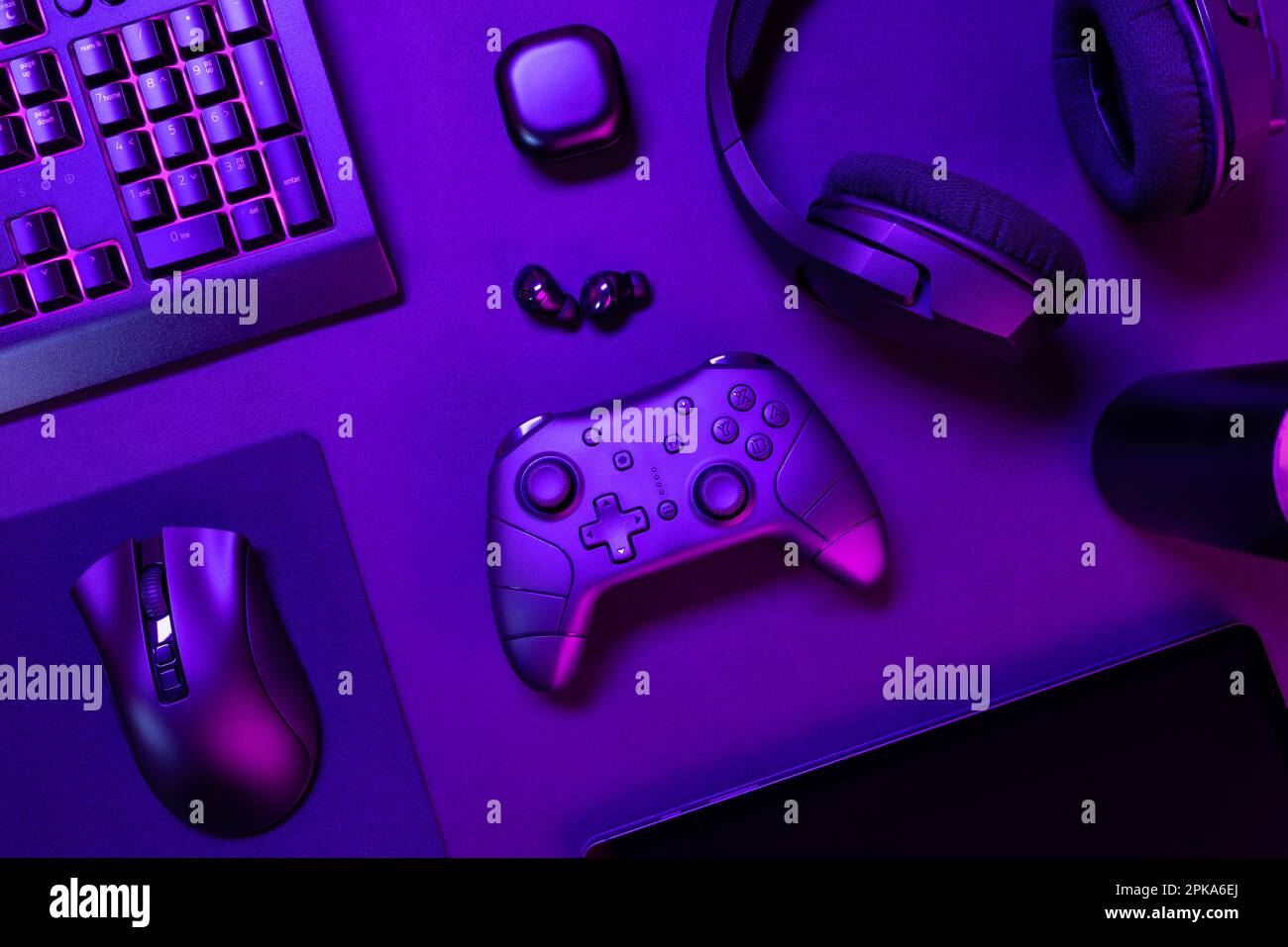 Directly above view of lit keyboard amidst various modern devices on ...