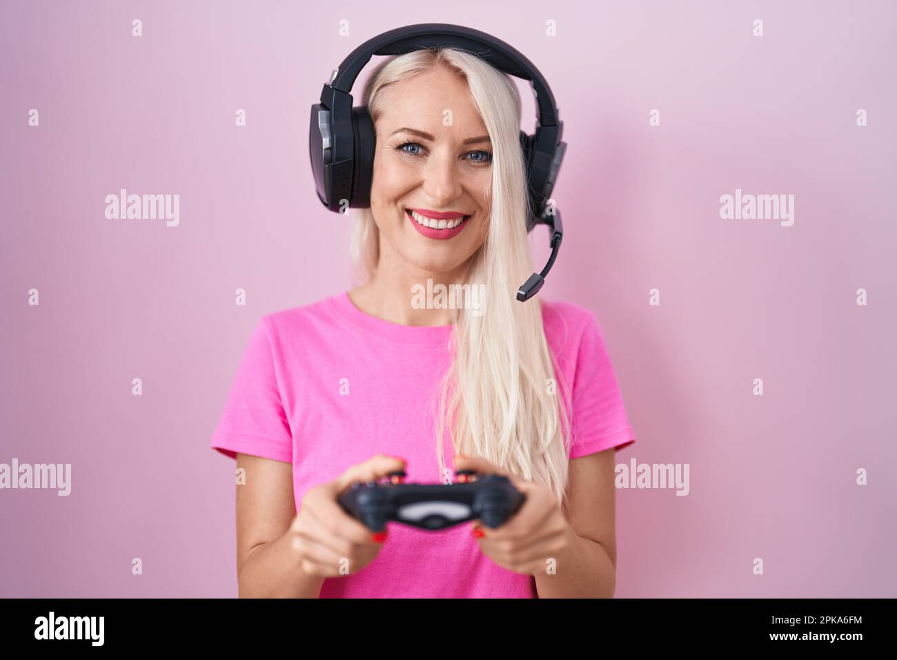 Caucasian woman playing video game holding controller smiling with a ...