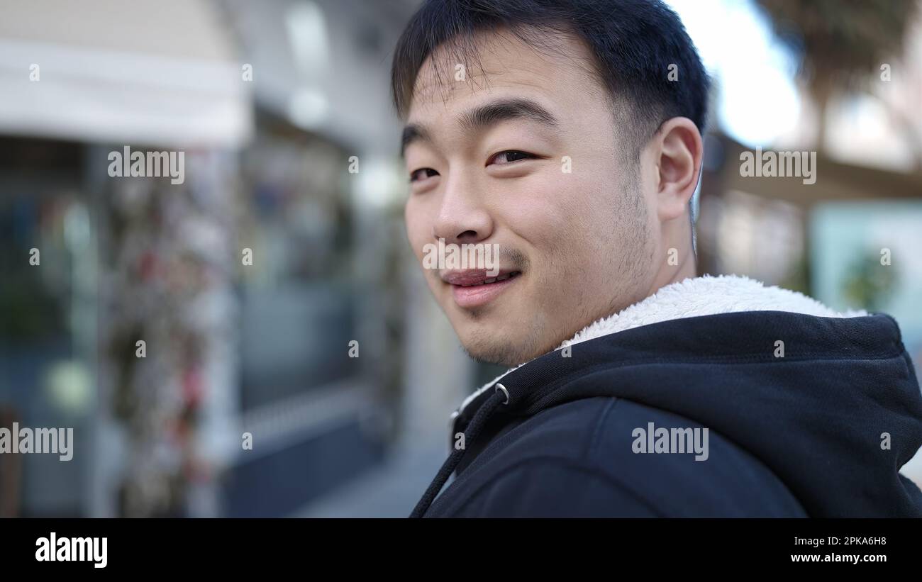 Young chinese man smiling confident standing at street Stock Photo - Alamy