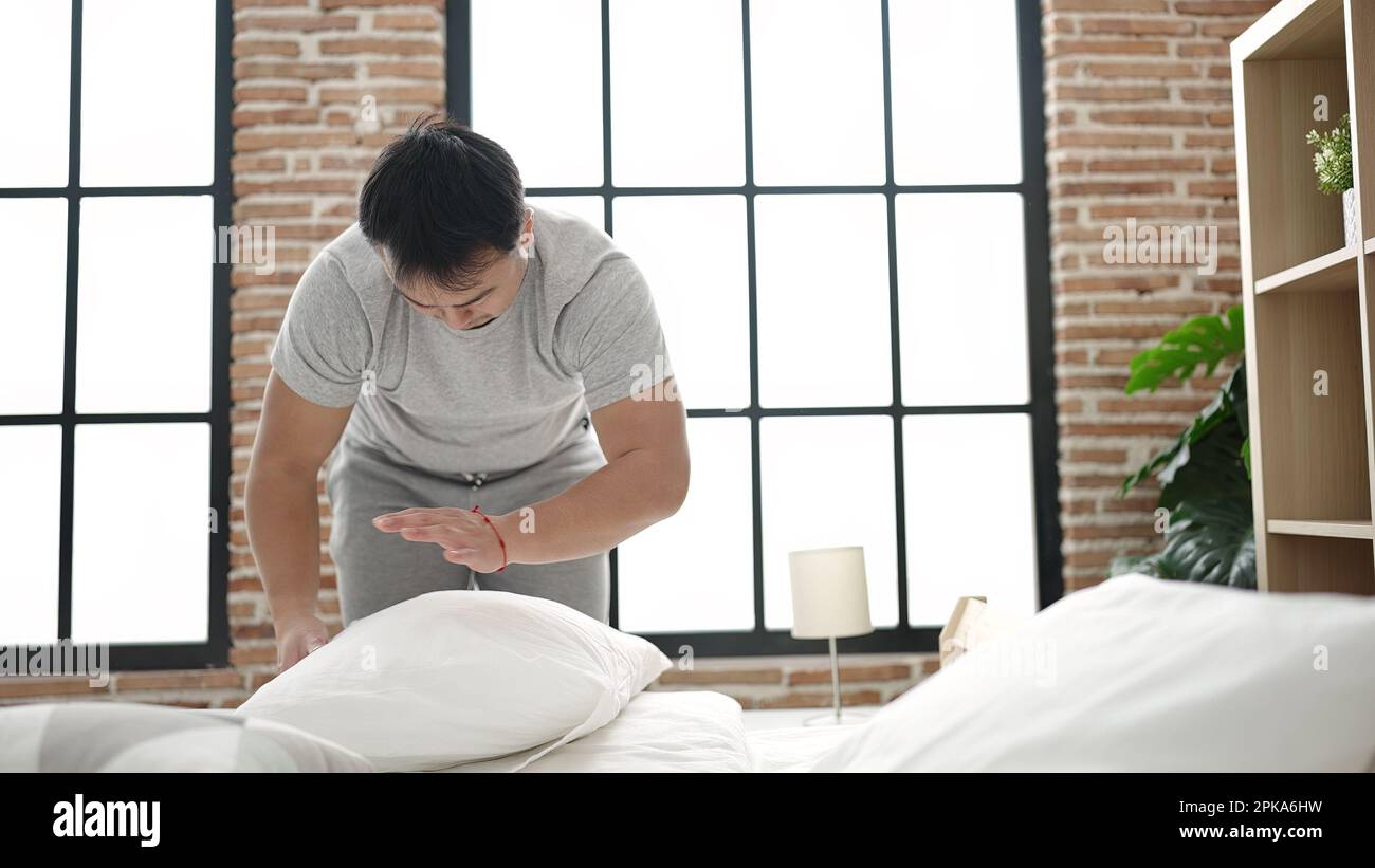 Young chinese man make bed at bedroom Stock Photo - Alamy