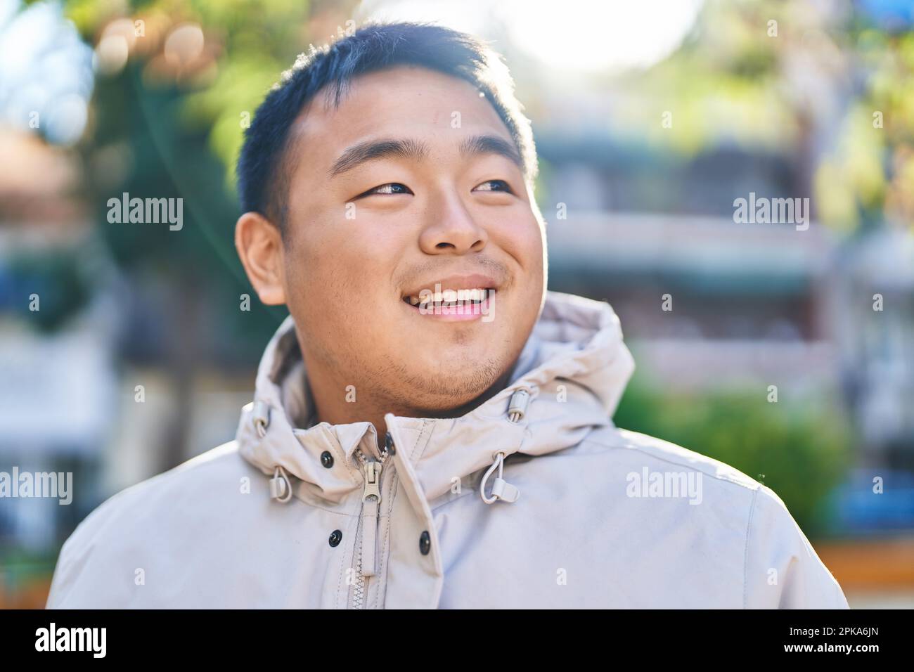 Young chinese man smiling confident standing at park Stock Photo - Alamy