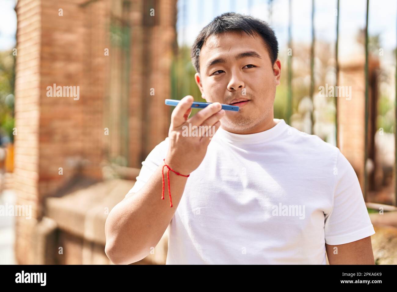 Young chinese man talking on the smartphone at street Stock Photo - Alamy