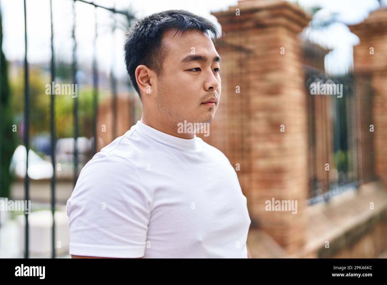 Young chinese man standing with relaxed expression at street Stock ...