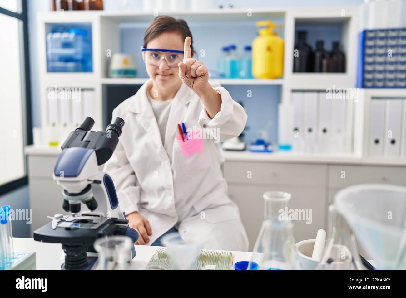 Hispanic girl with down syndrome working at scientist laboratory ...