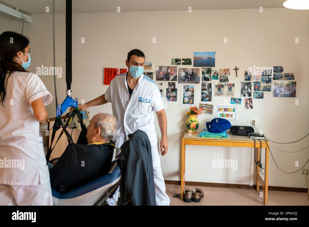 Two Nursing Assistants Put A Disabled Patient To Bed In Her Room At The