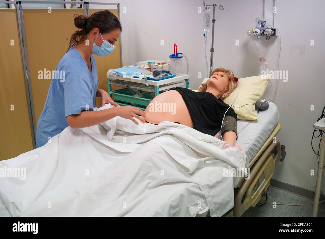 Students facing a post natal emergency follow procedures on a mannequin ...