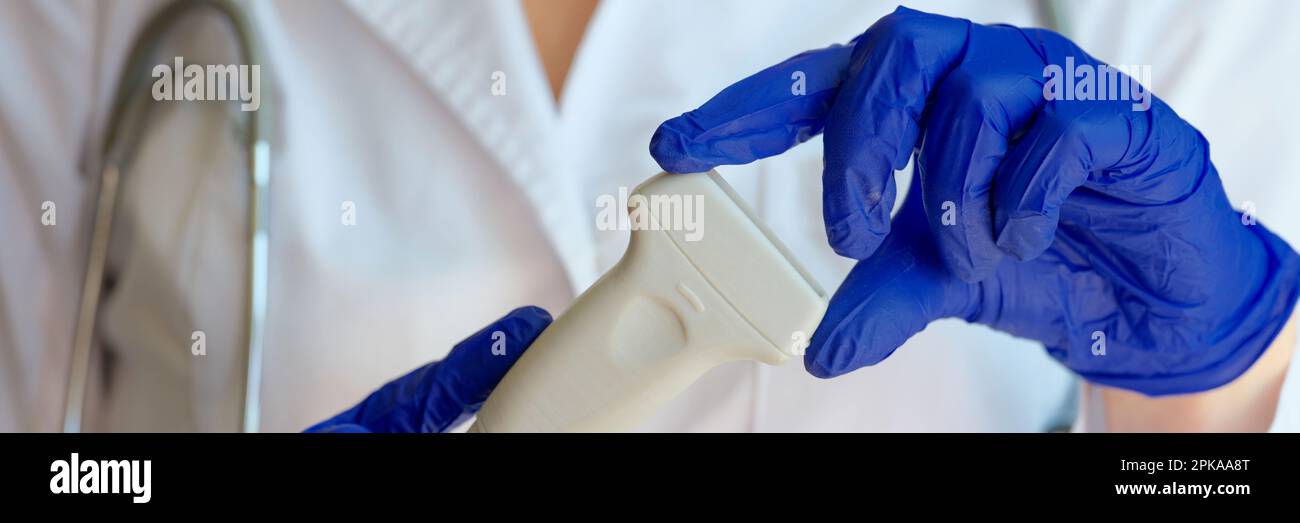 Practitioner in white gown showing ultrasound probe Stock Photo - Alamy