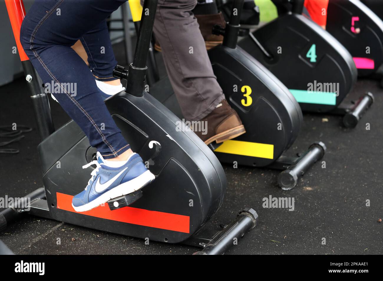 02.10.2022, France, , Paris - Close-up: People sitting on ergometers ...