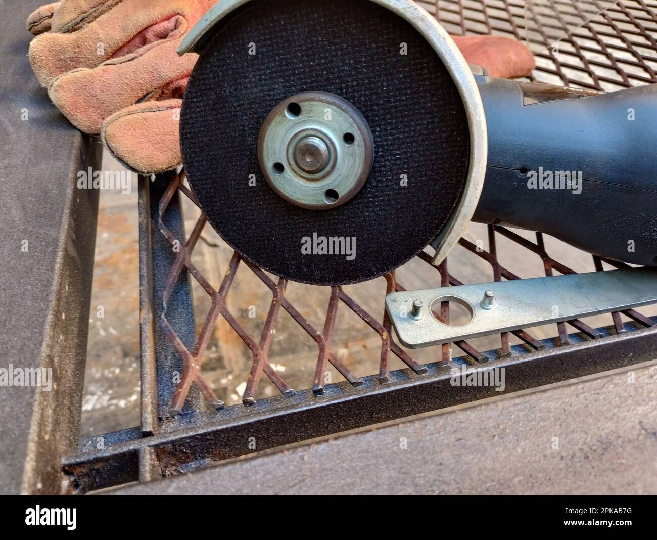 grinder for cutting a metal mesh with worn gloves Stock Photo - Alamy
