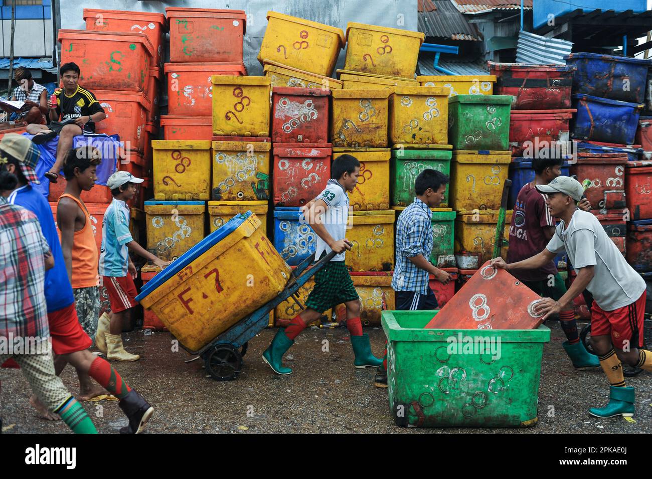 28.06.2014, Myanmar, , Yangon - Workers pull sack trucks with cool ...