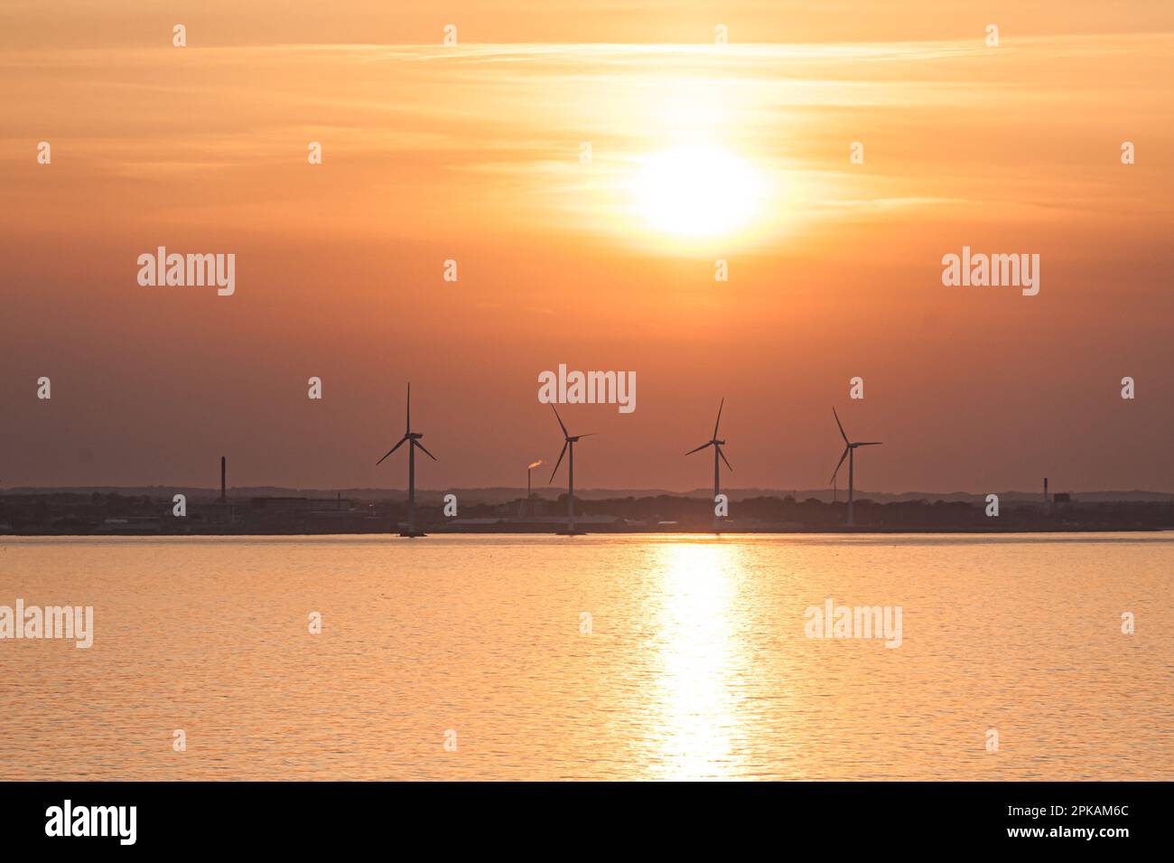 Sun setting over wind turbines on a summer evening Stock Photo - Alamy
