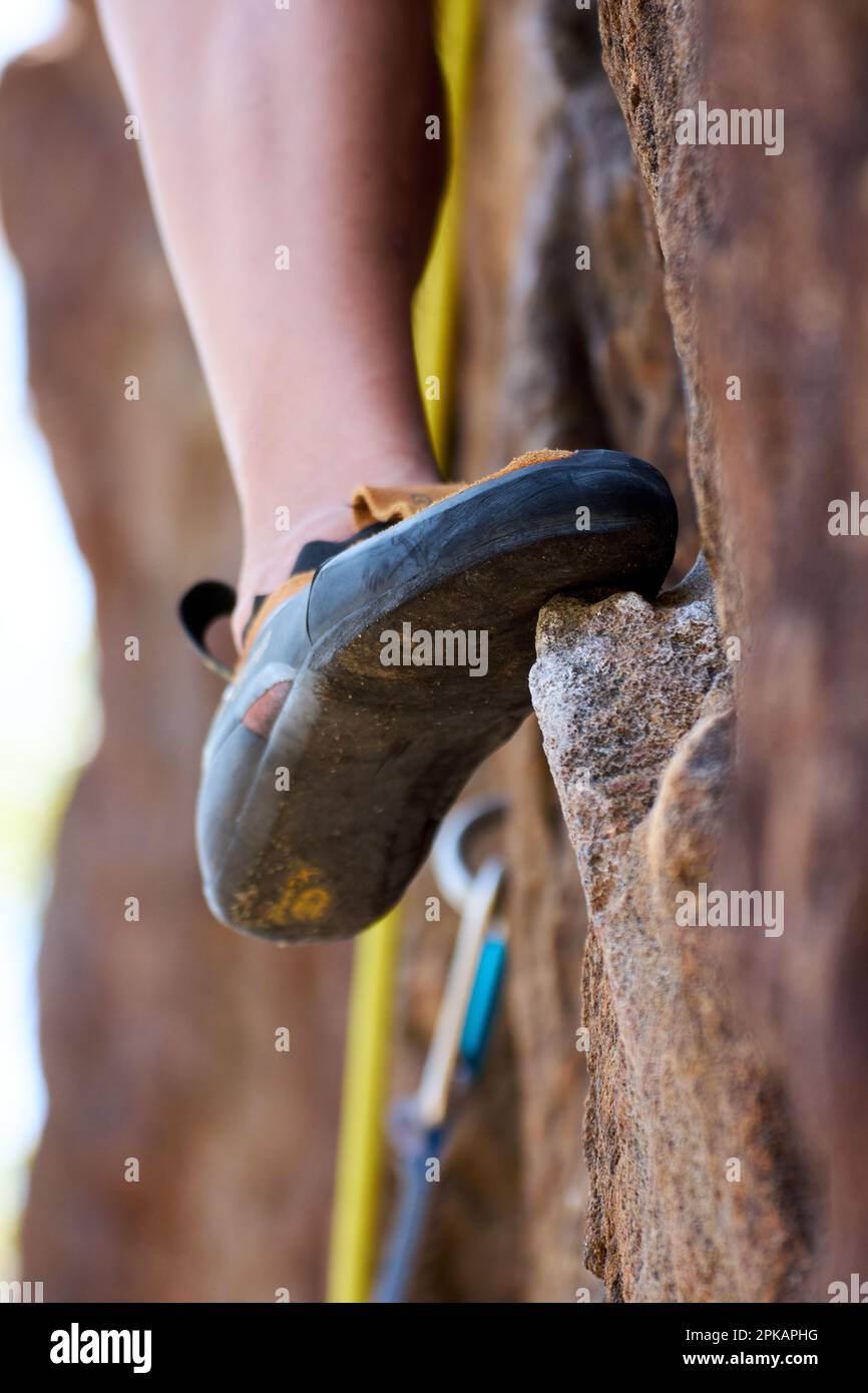 A vertical image of a rock climber's foot on a protruding rock Stock ...