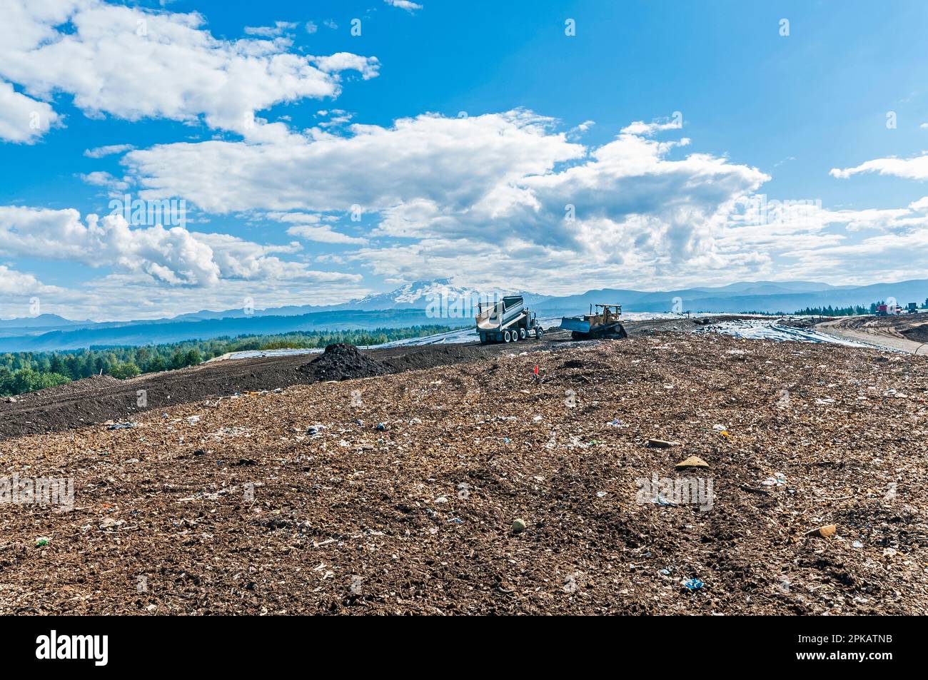 A bulldozer and a dump truck on freshly churned dirt in an active ...