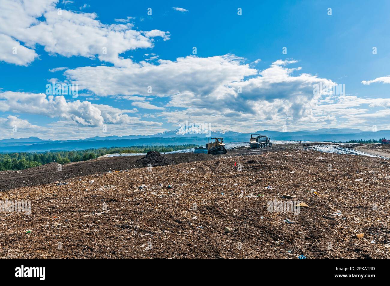 A bulldozer and a dump truck on freshly churned dirt in an active ...