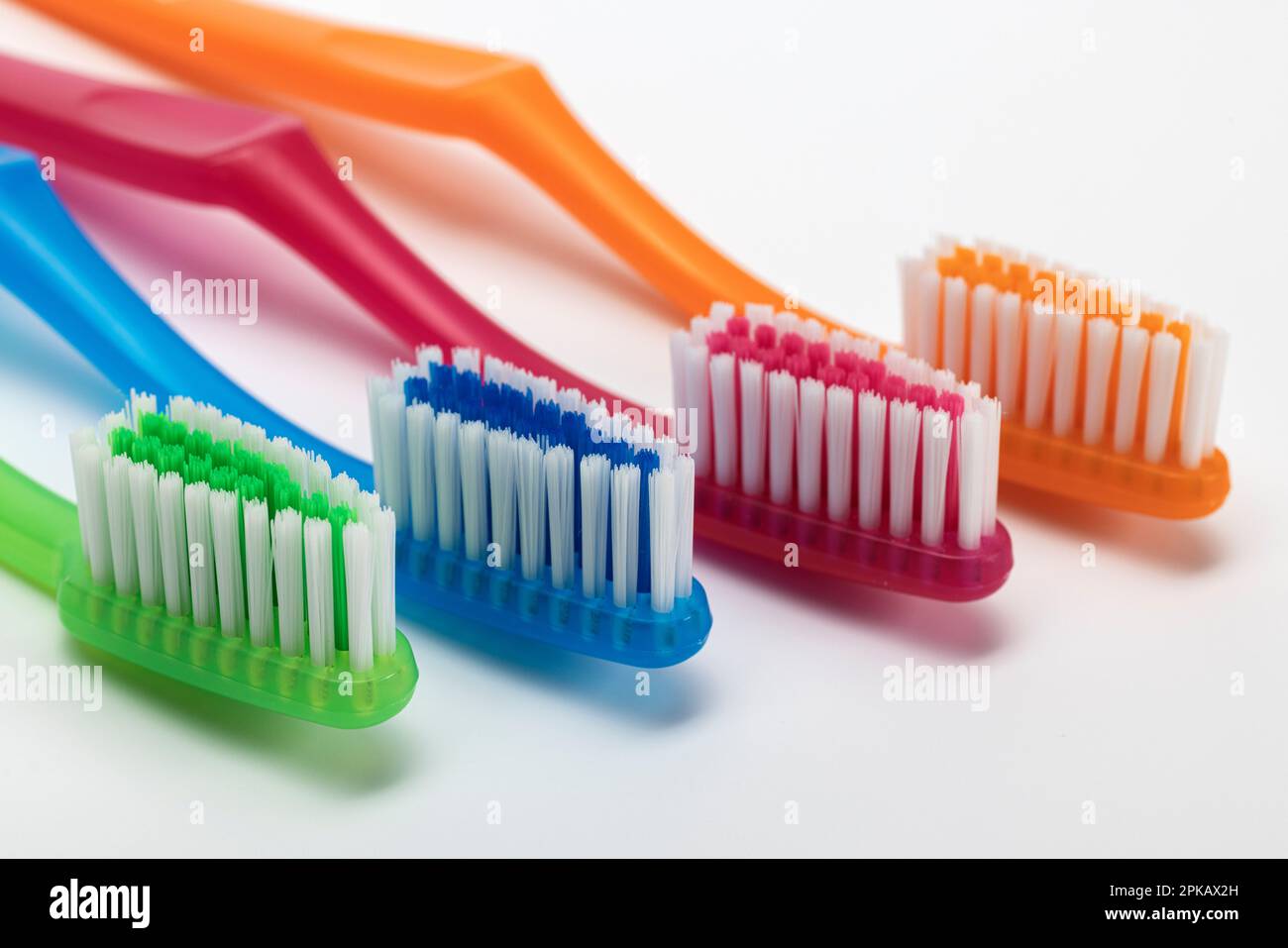 Four different colored manual toothbrushes, detail, white background ...