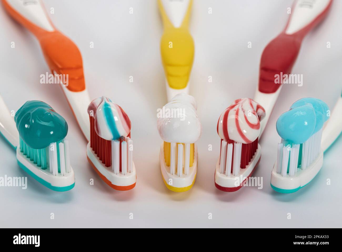 Five different colored manual toothbrushes with toothpaste, detail ...