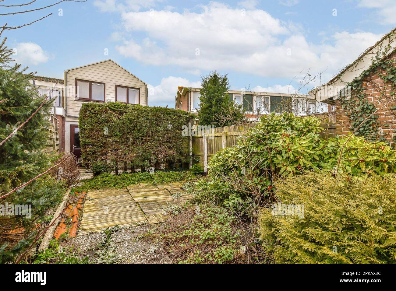 an outside view of a house with trees and bushes in the fore - image is ...