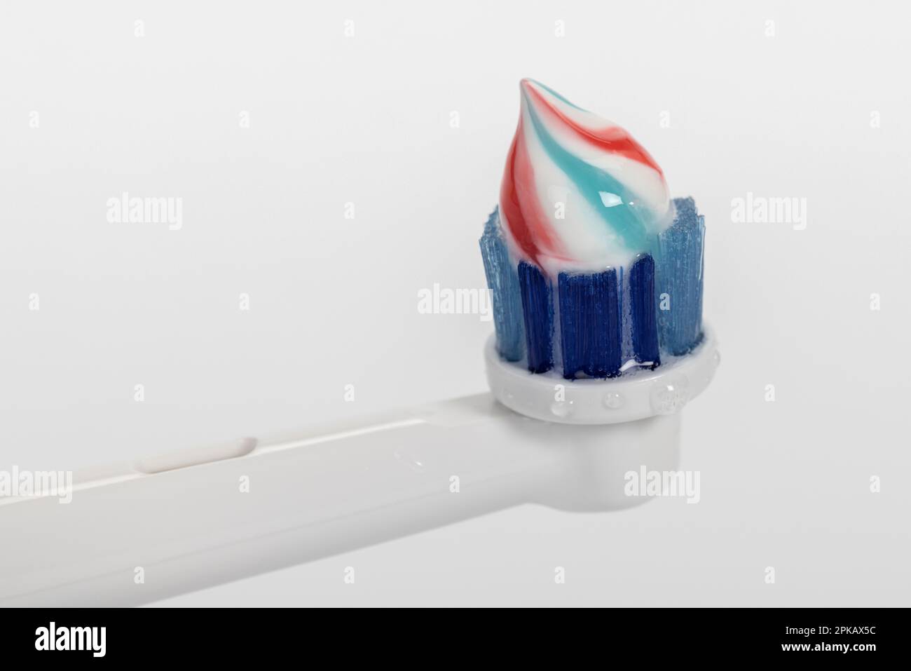 Toothpaste on toothbrush head of electric toothbrush, by Oral-B, detail ...