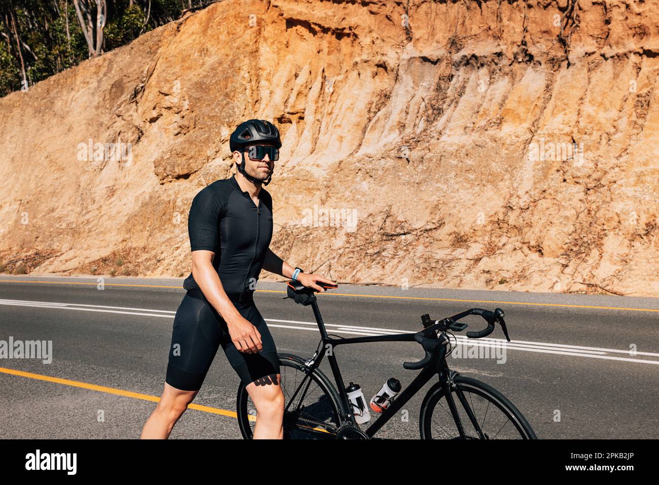 Professional cyclist walking with his road bike on a roadside Stock ...