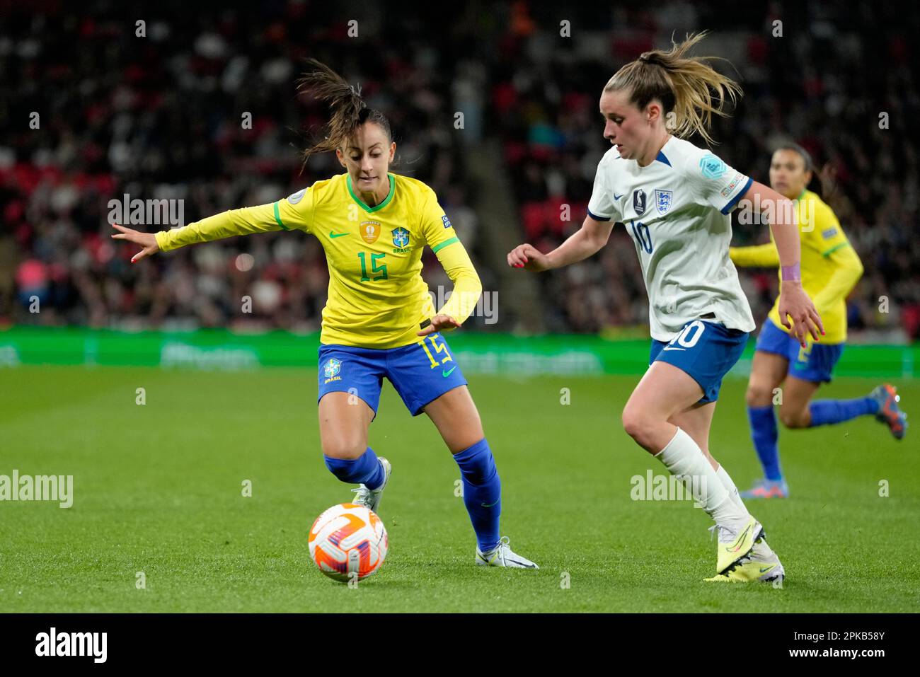 Brazil's Luana, left, tries to dribble the ball past England's Ella ...
