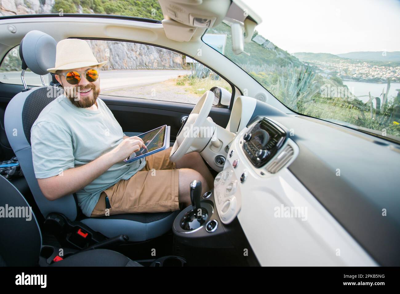 Hipster man looking on location navigation map in car, tourist traveler ...