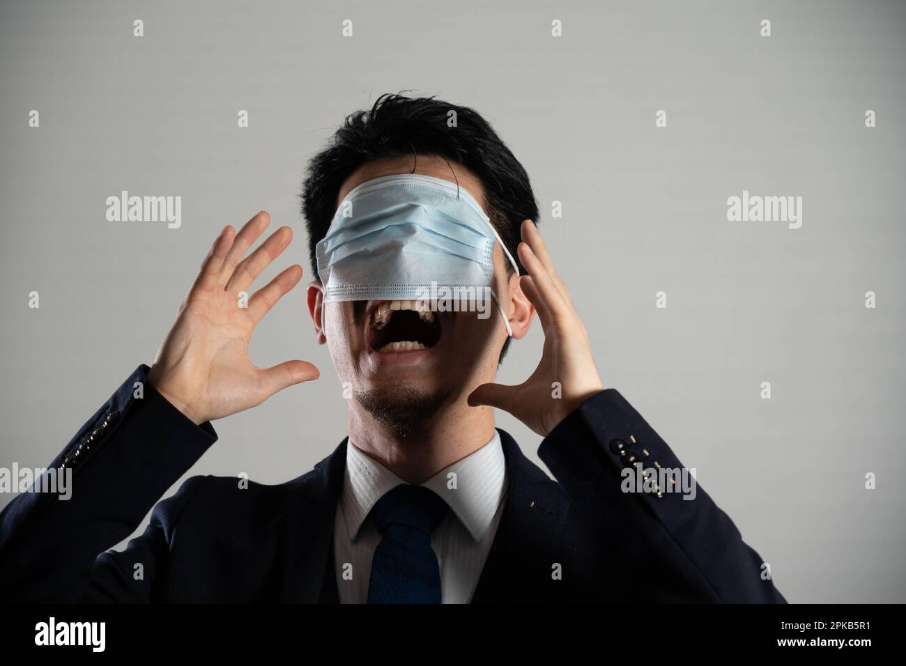Screaming man wearing a mask over his eyes Stock Photo - Alamy