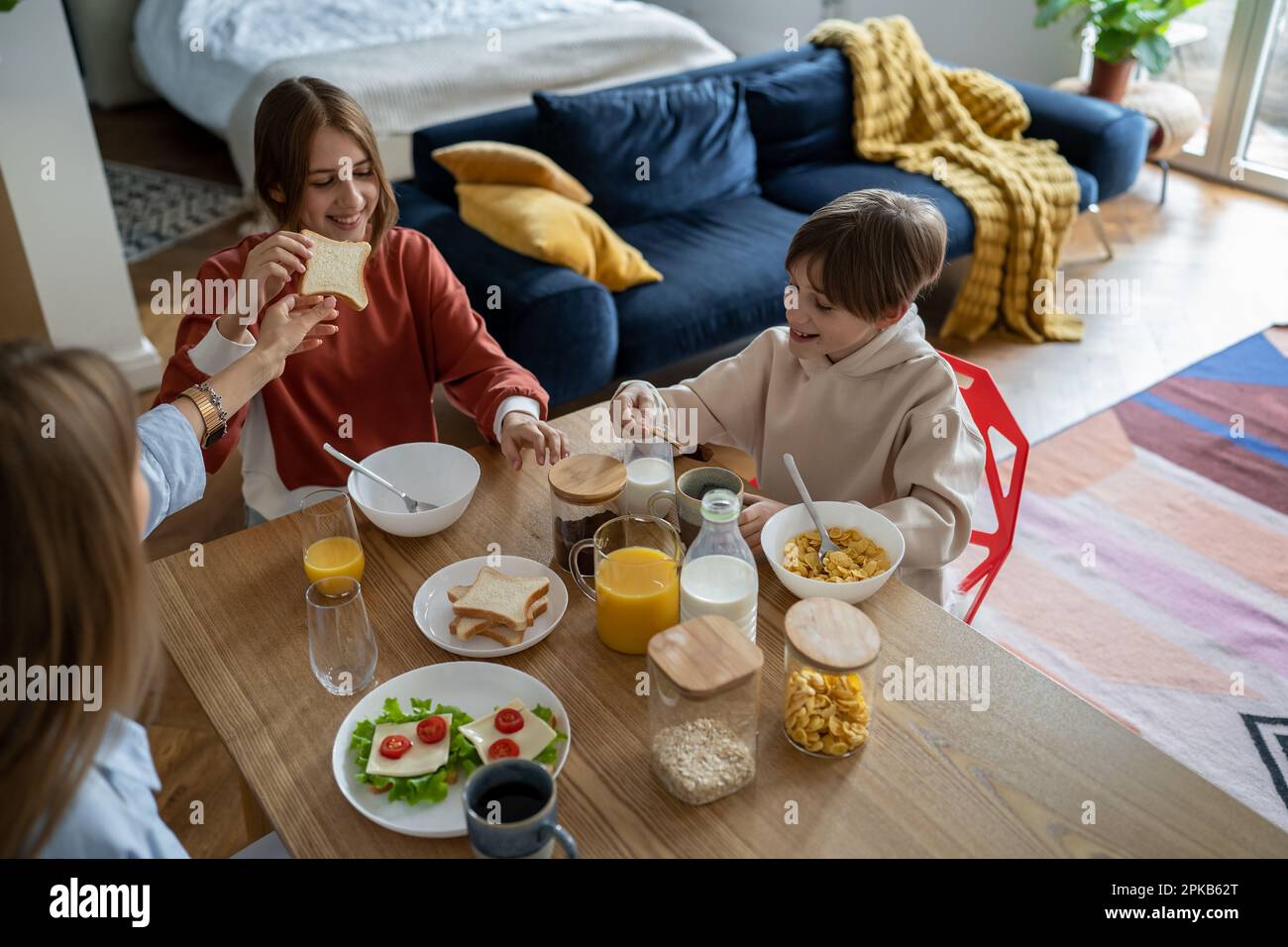 Happy smiling children brother and sister laughing while having breakfast with mom Stock Photo ...