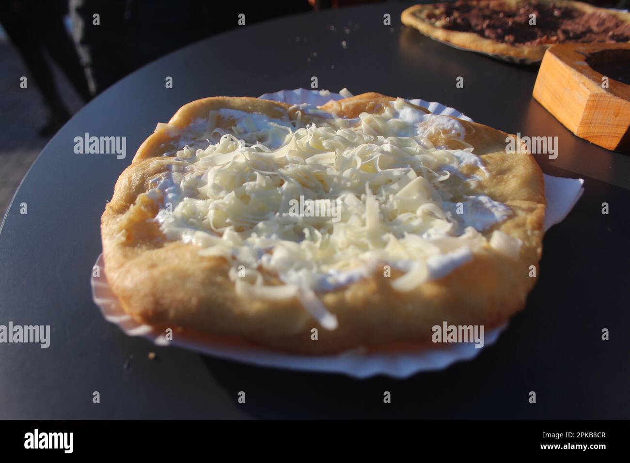 Traditional Langos with cheese and sour cream at the bar next to the ...