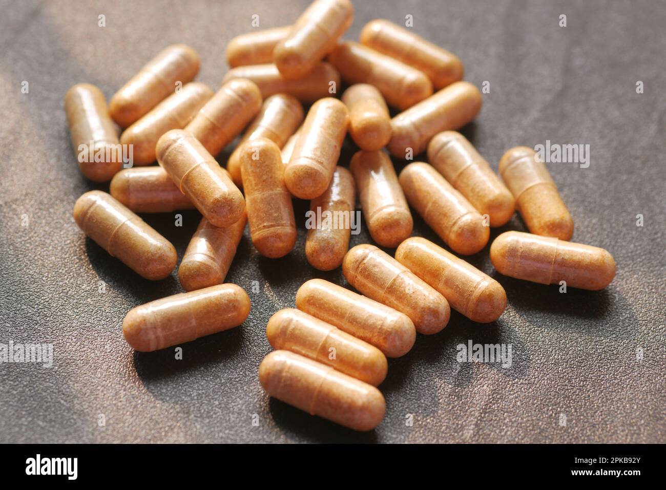 top view of herbal medicine capsule dropping on table Stock Photo - Alamy