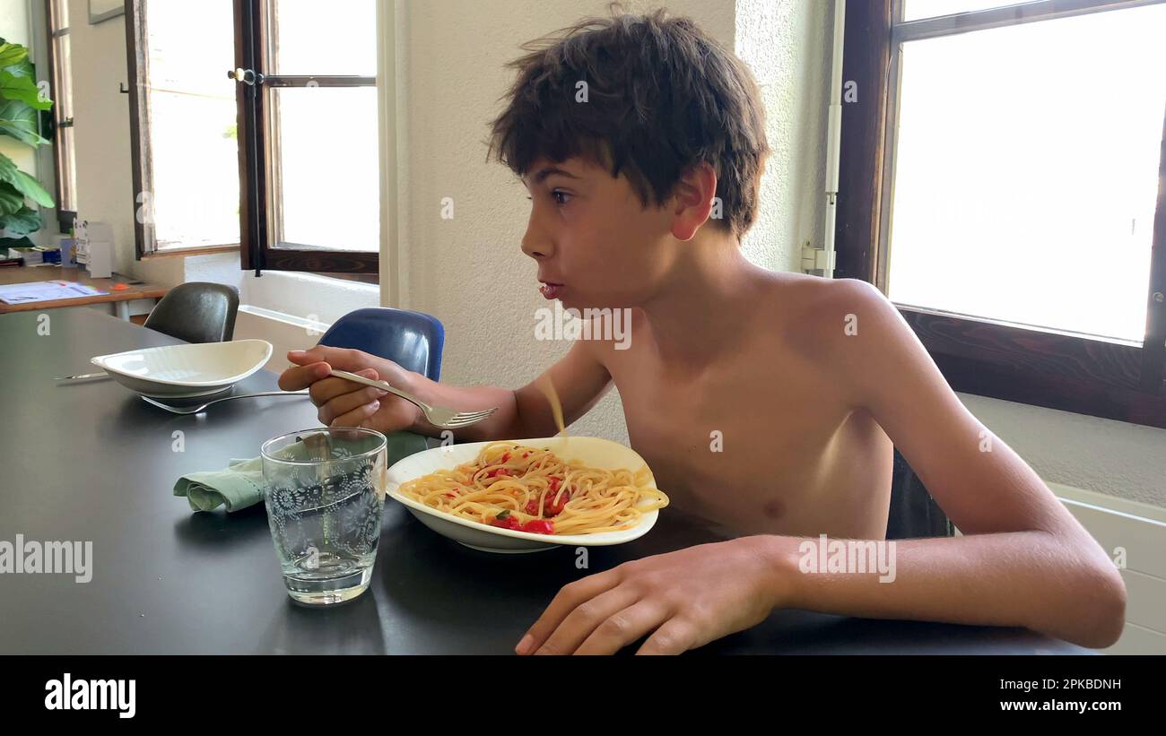 Young boy eating pasta. Child eats spaghetti Stock Photo - Alamy