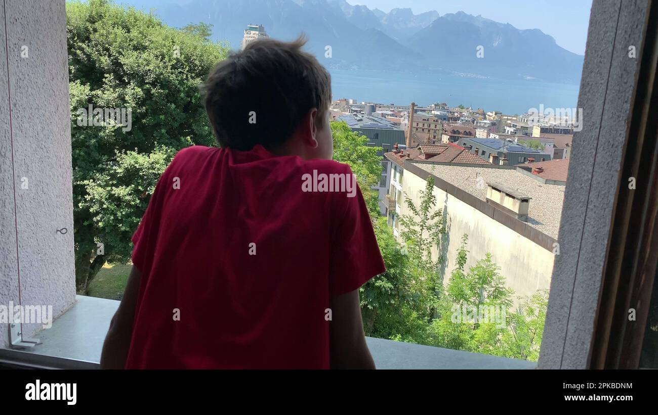 Young boy opening window looking outside. Child opens home windows ...