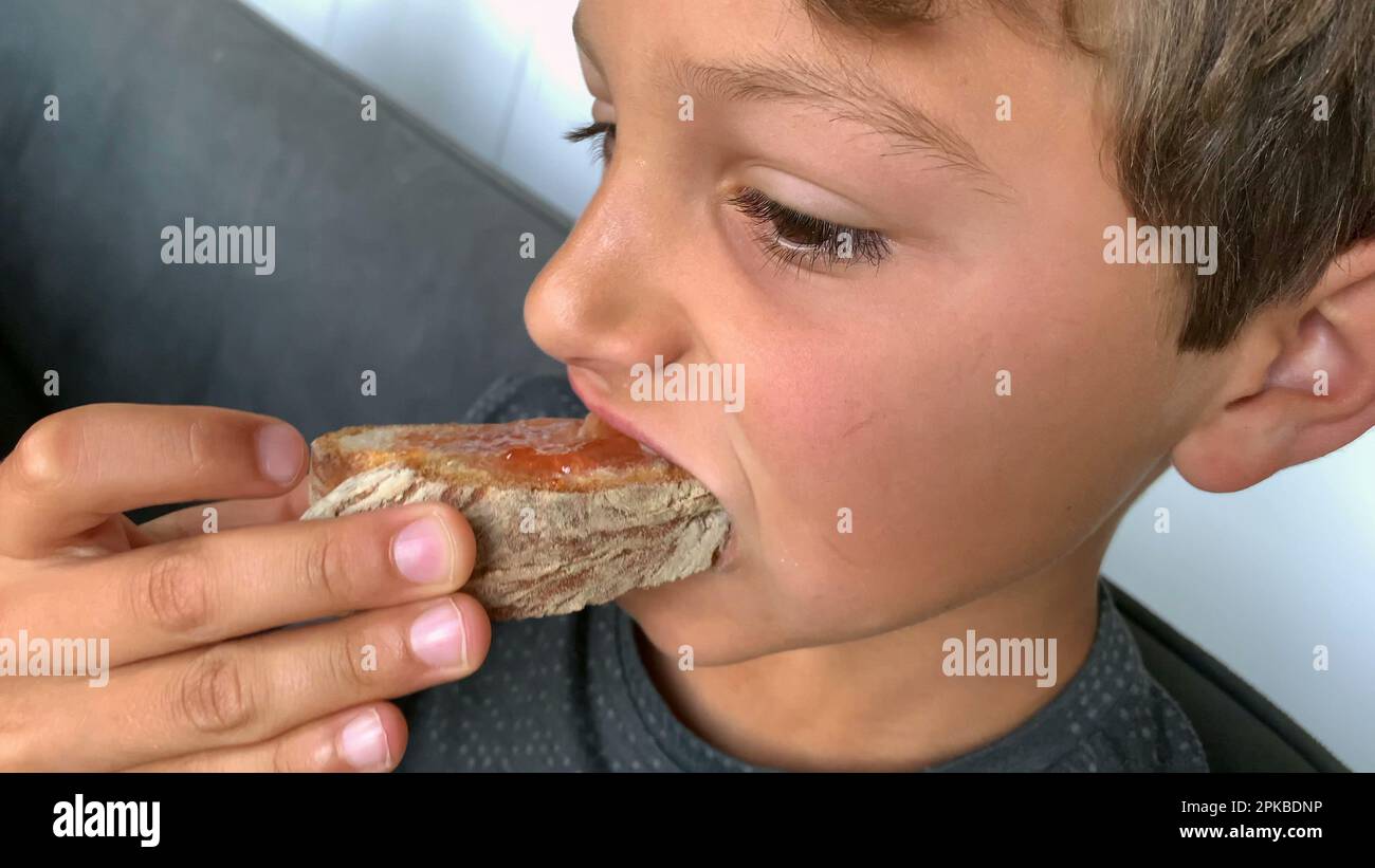 Young boy eating toast with jelly in morning breakfast. boy eats jelly ...
