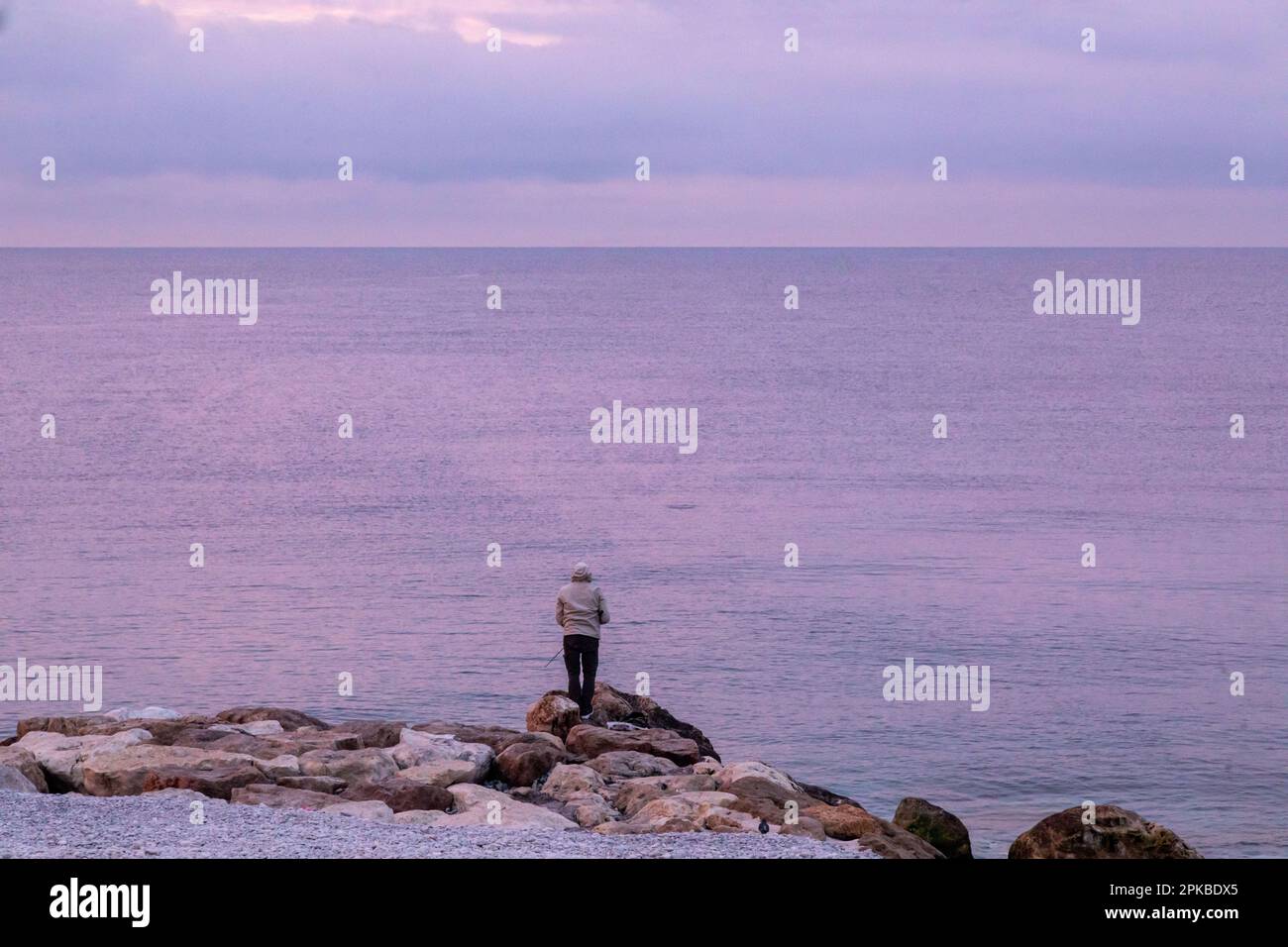 Fishing at dawn, NIce France, Promenade des Anglais, with pink skies ...